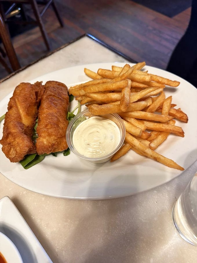 Golden-battered fish that shatters with each bite, paired with perfectly crisp fries—this isn't just fish and chips, it's edible poetry.