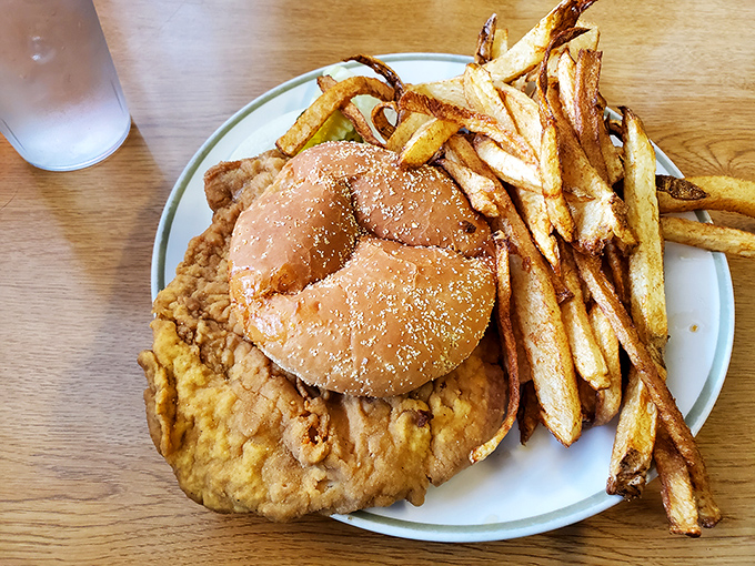 This chicken fried steak sandwich isn't messing around. The golden-brown behemoth threatens to escape its bun while crispy fries stand guard.