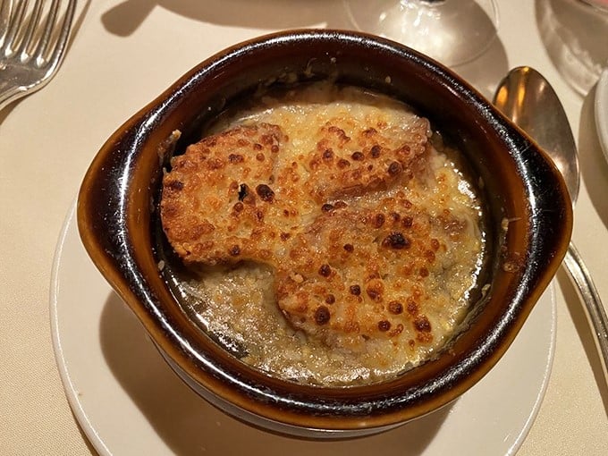 The French onion soup arrives with a crown of perfectly browned cheese that stretches with each spoonful. This isn't just soup&mdash;it's a warm, savory hug in a bowl.