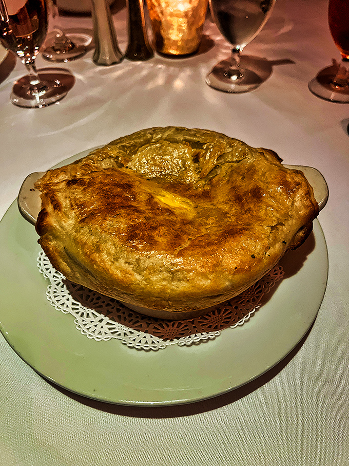 The French onion soup arrives like a golden-domed cathedral of cheese, hiding a rich, savory congregation of caramelized onions beneath its bubbling roof.