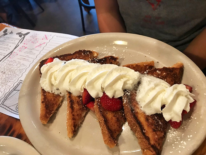 French toast triangles standing at attention, crowned with whipped cream and fresh strawberries. Breakfast or dessert? The line deliciously blurs.