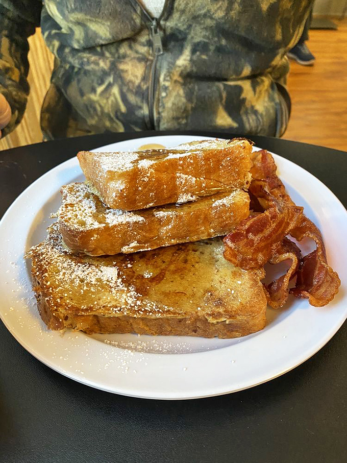 French toast that's achieved golden-brown perfection, dusted with powdered sugar and flanked by bacon that's exactly how bacon should be.