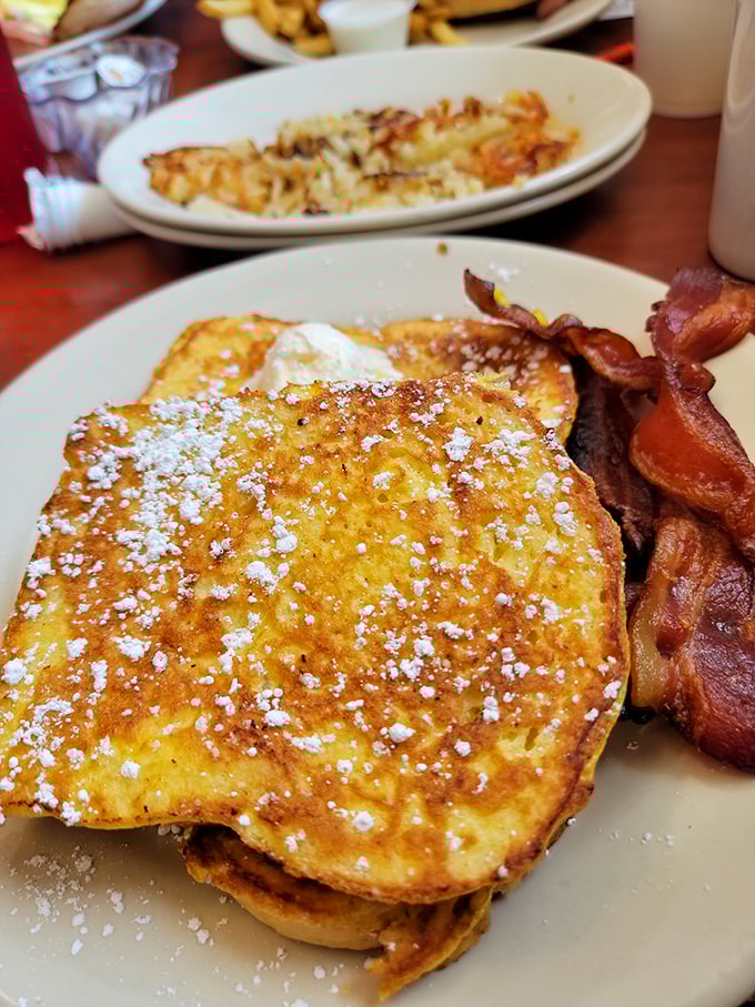 Golden-brown French toast dusted with powdered sugar alongside perfectly crisp bacon&mdash;breakfast's dynamic duo performing their greatest hits on a plate.