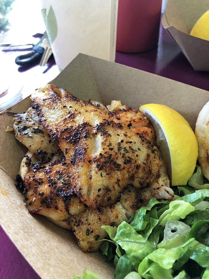 Beach dining perfection: a blackened grouper sandwich that makes you wonder why you ever eat anything else. That sauce? Liquid gold.
