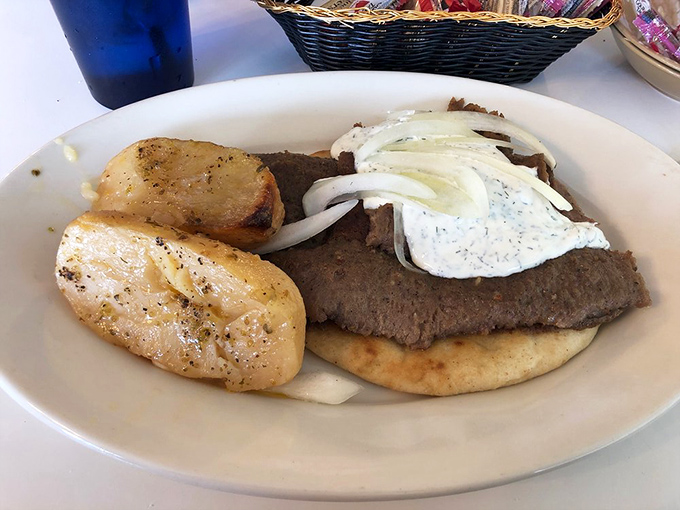 Meat so tender it practically surrenders to your fork, alongside potatoes that somehow manage to be both fluffy and crispy. This isn't a meal—it's a Mediterranean miracle.