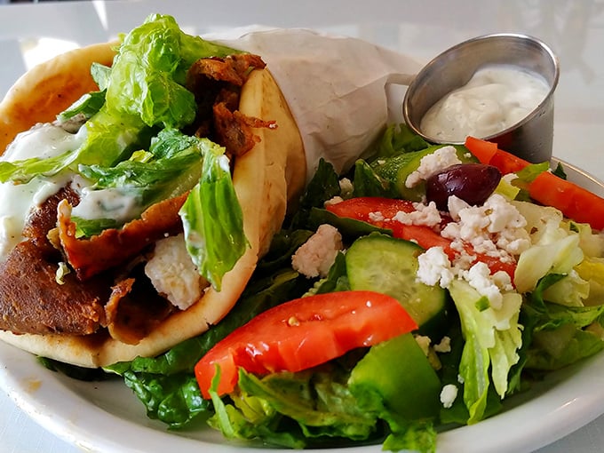 The holy trinity of gyro perfection: seasoned meat, fresh veggies, and tzatziki sauce, accompanied by a Greek salad that didn't skimp on the feta.