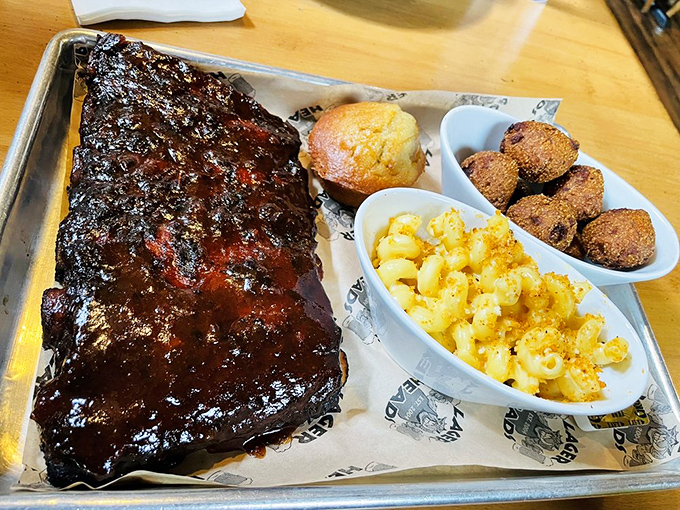 Behold the star of the show! These ribs with their glistening bark, cornbread sidekick, and mac & cheese confidant are ready for their close-up.