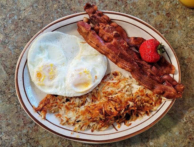 Breakfast nirvana achieved: those legendary hash browns sharing the spotlight with perfectly crisp bacon and sunny-side-up eggs. The holy trinity of morning bliss.