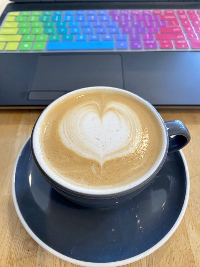 Heart-shaped latte art that deserves its own tiny museum exhibit, perfectly positioned for that "I'm working, but also living my best life" aesthetic.