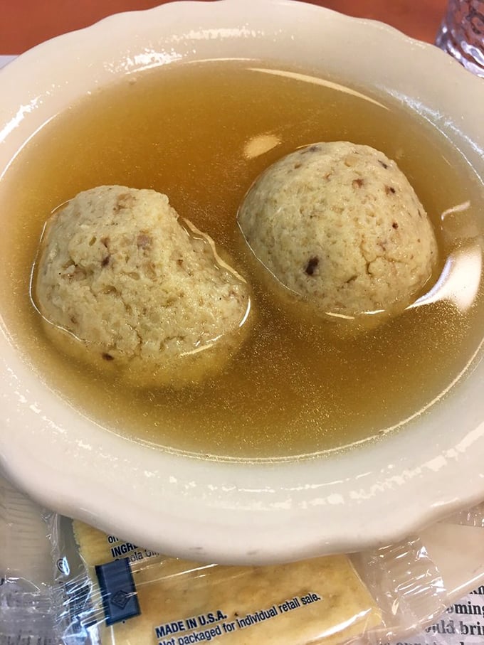 Two perfect matzo balls floating in golden chicken broth&mdash;like edible life preservers in a sea of comfort that grandmother would approve of.