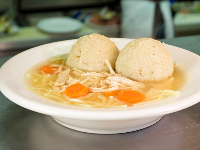 Behold the golden elixir of life! Two perfect matzo balls floating like dumplings from heaven in chicken soup that grandmothers everywhere would approve of.
