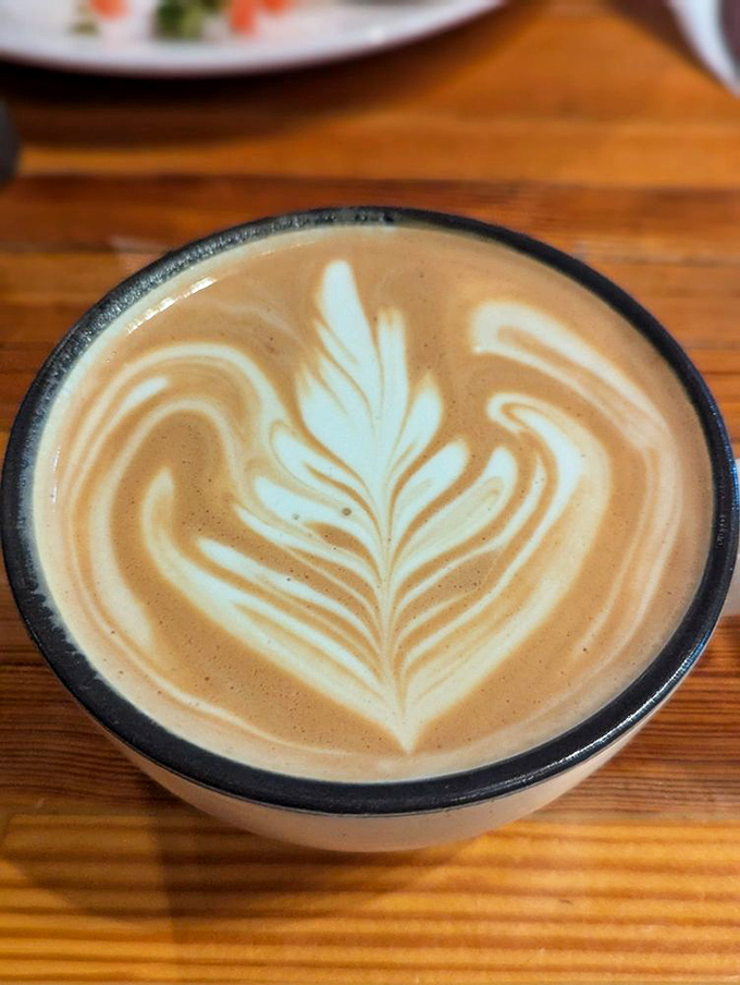 Latte art so pretty you almost feel guilty disturbing it. Almost. That leaf pattern deserves its own Instagram account.