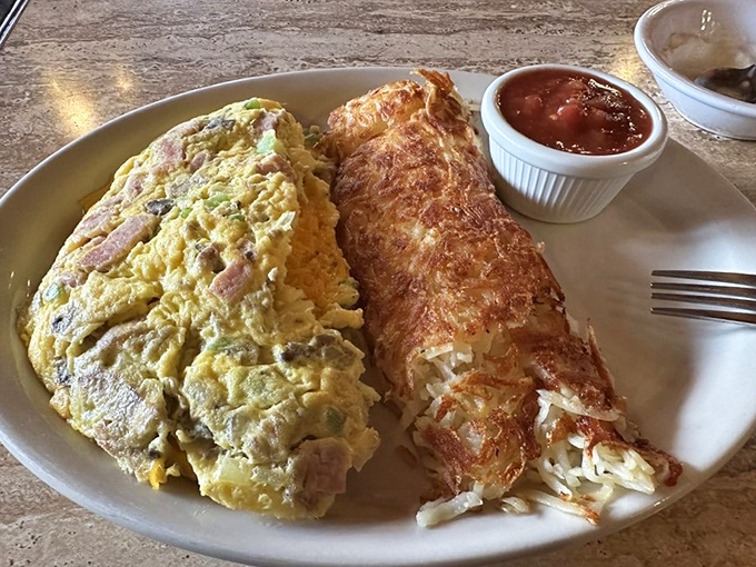 Behold the star attraction: a ham-packed omelet that could feed a small village, paired with perfectly crispy hash browns.