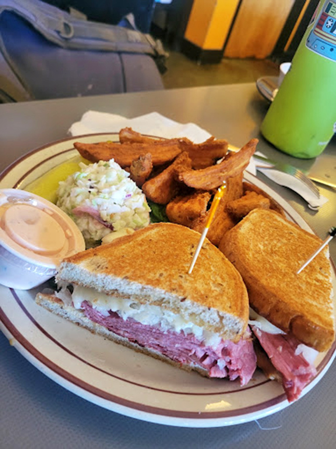 This isn't just a sandwich; it's architecture. Perfectly stacked pastrami, creamy coleslaw, and those golden-brown potato wedges deserve their own Food Network special.