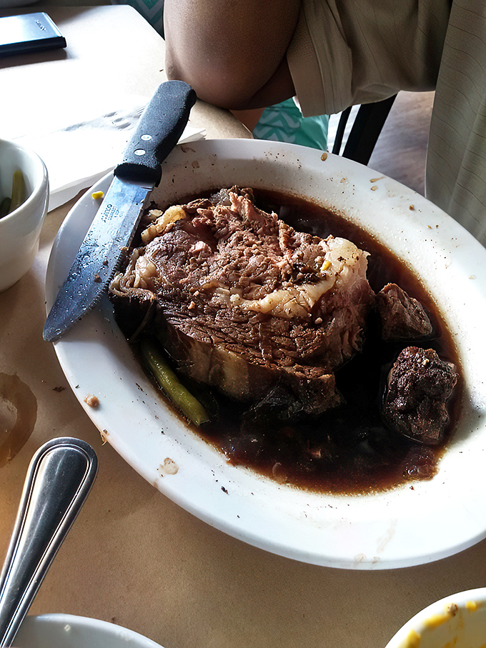 This isn't just prime rib; it's a carnivore's sonnet—a perfectly seasoned masterpiece swimming in savory au jus that makes vegetarians question their life choices.