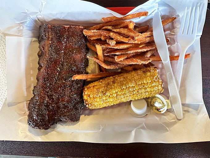 Barbecue perfection on a paper-lined tray &ndash; those ribs with their mahogany bark, sweet corn, and crispy fries are the holy trinity of comfort.