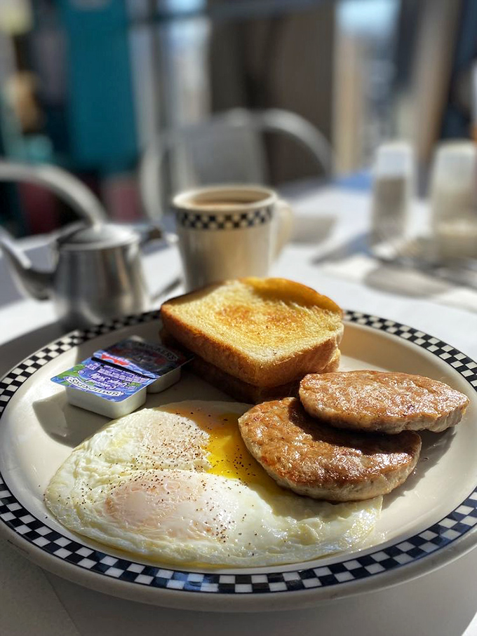 Breakfast perfection doesn't need fancy plating. This sunny-side up egg with sausage patties and golden toast proves that classics endure for good reason.
