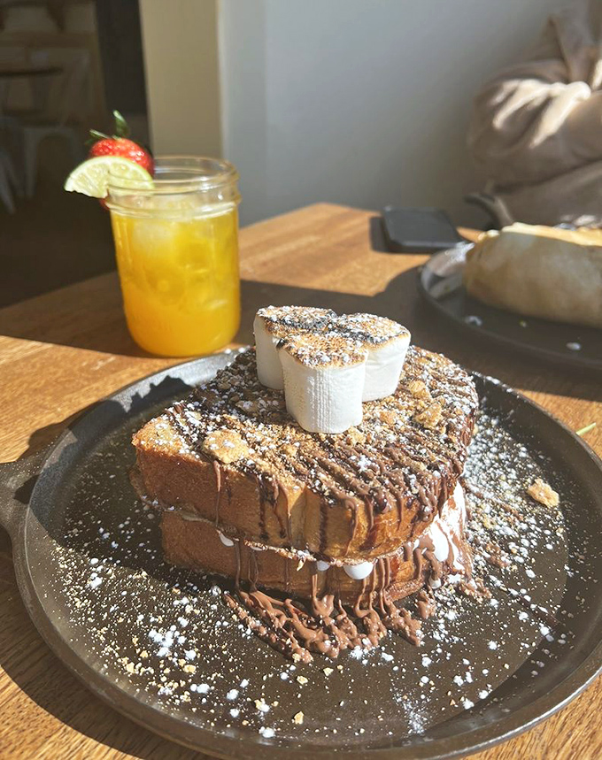 This isn't just French toast – it's a towering monument to decadence with chocolate drizzle, powdered sugar, and what appears to be a scoop of heaven on top.