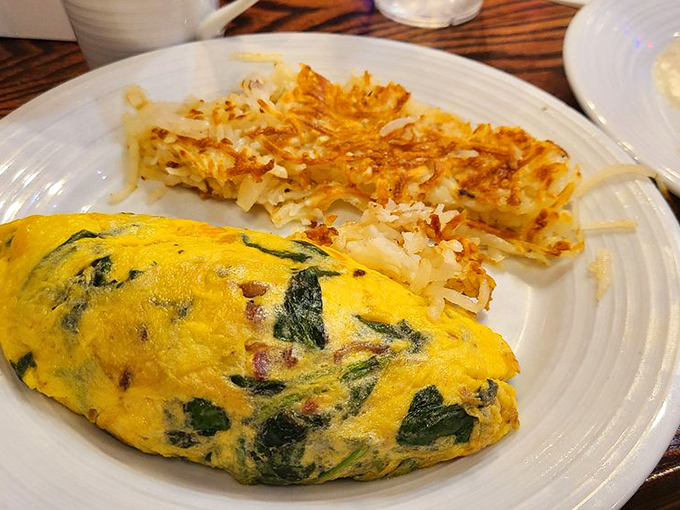This spinach omelet isn't just eating your greens&mdash;it's experiencing them in their most glorious form, paired with perfectly crispy hash browns.