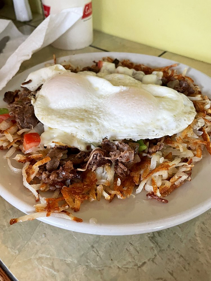 Hash brown heaven! Crispy edges, tender centers, topped with eggs and savory meat. This is the breakfast that dreams&mdash;and road trips&mdash;are made of.