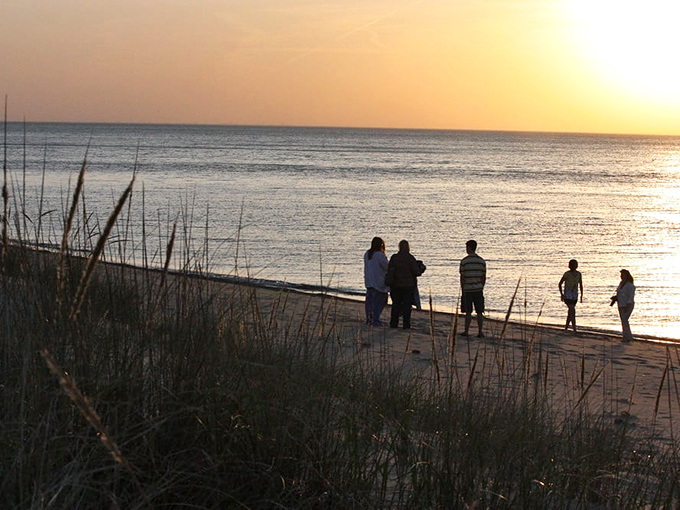 Sunset seekers finding their moment of zen. There's something magical about watching day turn to dusk with your toes in the sand of a hidden Indiana treasure.