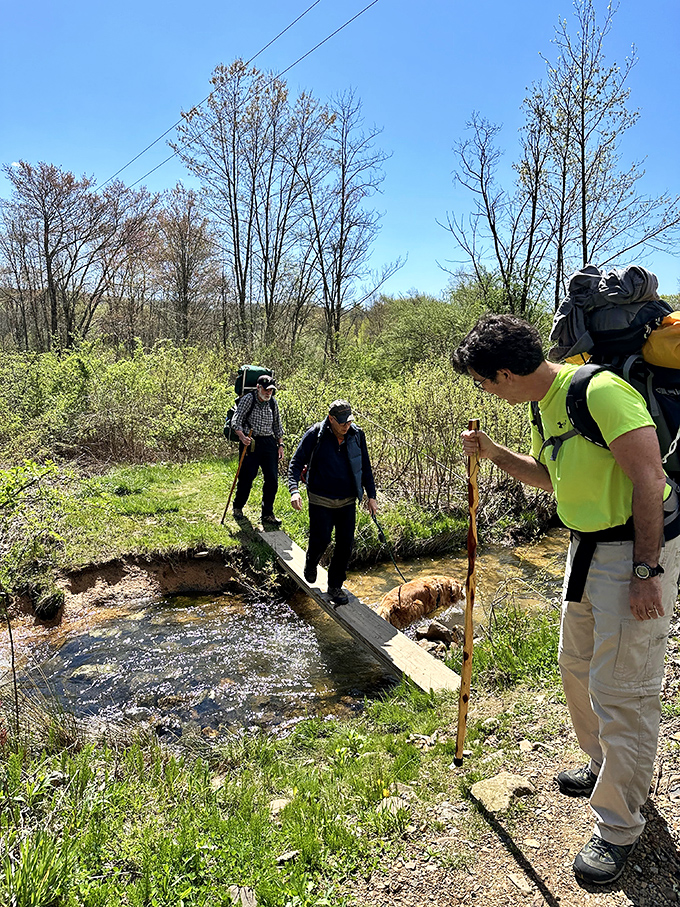 Adventure seekers navigate a humble stream crossing, proving that sometimes the best outdoor moments happen when you're just trying not to get your socks wet.