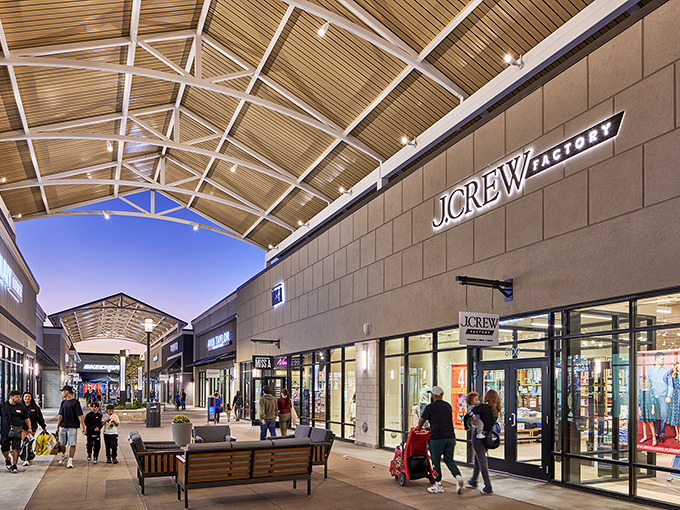Evening shopping at J.Crew Factory takes on a magical quality under the wooden-beamed canopies, where style meets savings in perfect harmony.