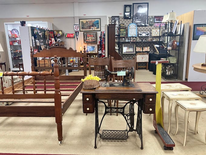 That antique sewing machine base repurposed as a table whispers tales of garments made, while wooden bed frames await their next chapter.