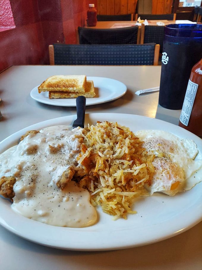 Country fried steak smothered in gravy with a side of golden hash browns. When breakfast looks like this, hitting the snooze button becomes a crime against humanity.