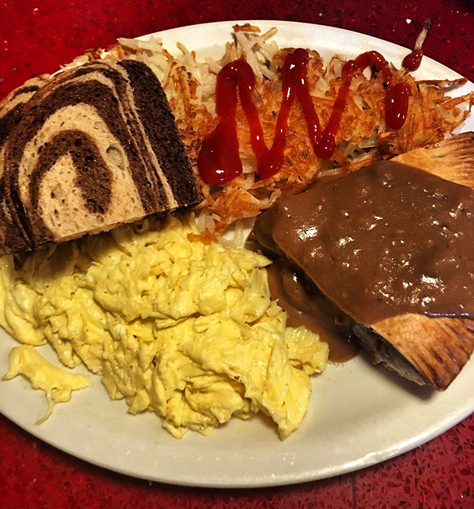 Breakfast alchemy at its finest&mdash;a perfect omelet alongside crispy hash browns and toast. The coffee mug's smile says it all. 