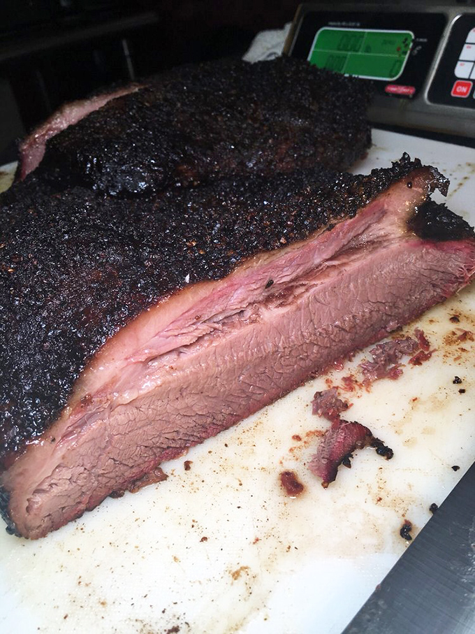 Behold the holy grail of barbecue: brisket with that glistening black bark giving way to a perfect pink smoke ring. Poetry in meat form.
