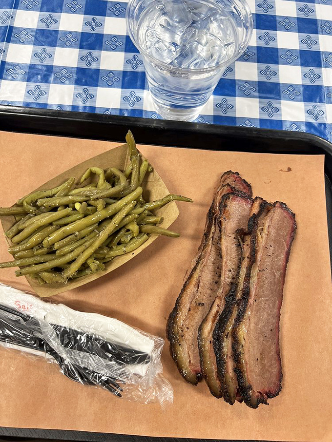 Brisket with that perfect pink smoke ring sitting alongside green beans that actually look like vegetables, not cafeteria punishment. This is balance in the BBQ universe.
