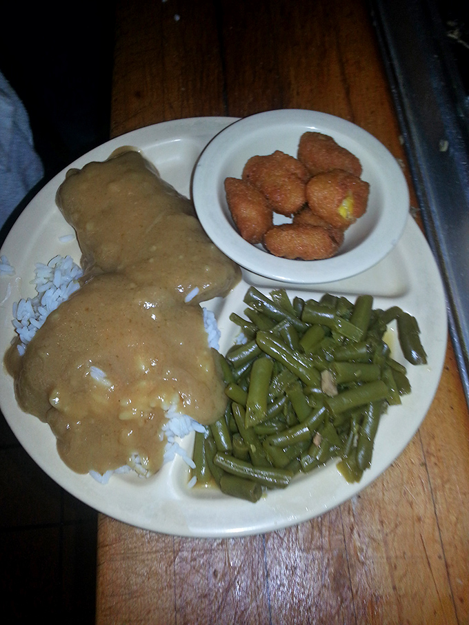 Southern comfort on a plate&mdash;chicken fried steak swimming in gravy with green beans and hush puppies standing by for backup duty.