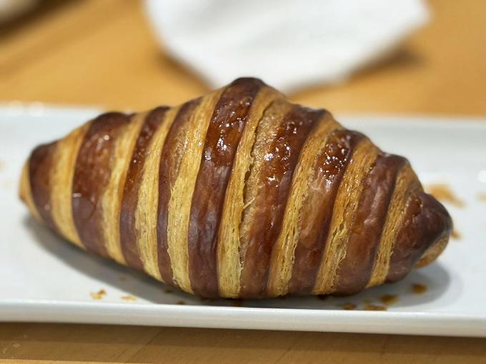 This chocolate croissant isn't just breakfast—it's an edible sunrise. Layers of buttery pastry hiding rivers of chocolate that would make Willy Wonka jealous.