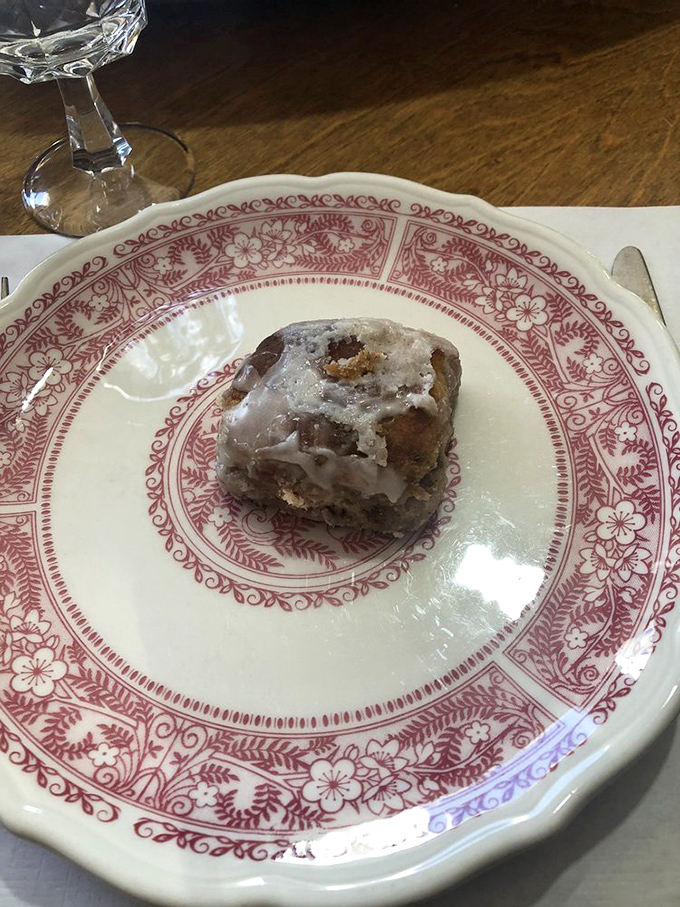 One perfect cinnamon roll sitting pretty on vintage china&mdash;this isn't dessert, it's edible therapy with a side of nostalgia.