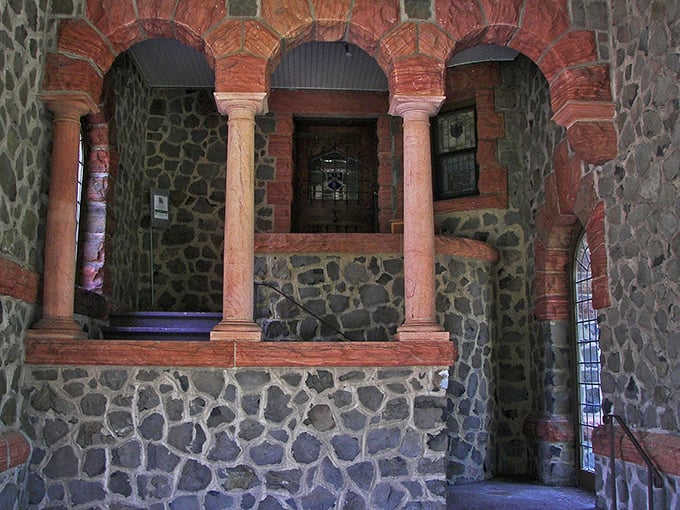 Arched stonework and coral-hued columns create a dramatic entryway that whispers tales of Gatsby-era soir&eacute;es and Prohibition secrets.