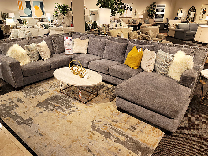 Plush sectionals arranged like an invitation to sink in and stay awhile. The yellow accent pillows are saying, "Yes, comfort can be stylish too."