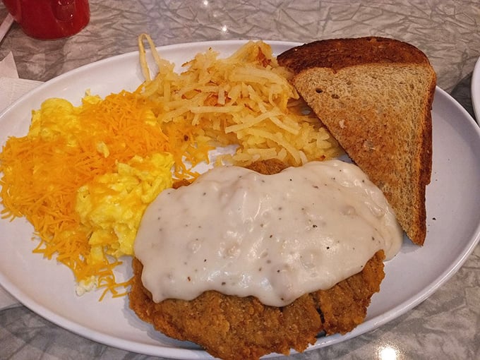 The famous country fried steak in all its glory &ndash; golden exterior, smothered in gravy, with eggs and hash browns standing by.