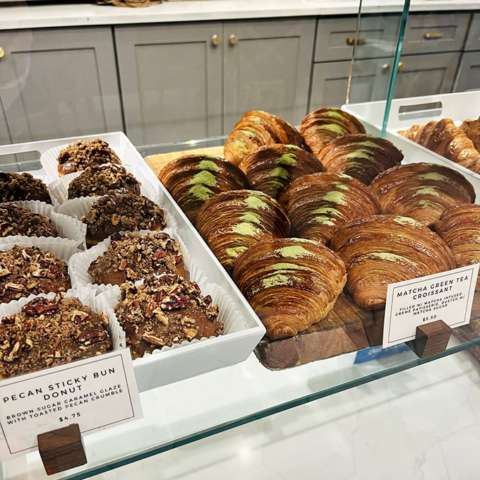 Pastry perfection on display: matcha croissants and pecan sticky buns waiting to transform your ordinary day into an extraordinary one.