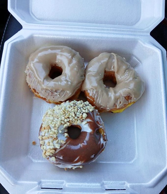 Three perfect specimens of donut artistry. That half-chocolate, half-peanut creation is the dessert equivalent of having your cake and eating it too.