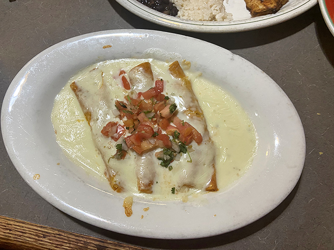 This enchilada isn't just swimming in queso&mdash;it's doing the backstroke in a pool of melty perfection, topped with fresh pico de gallo.