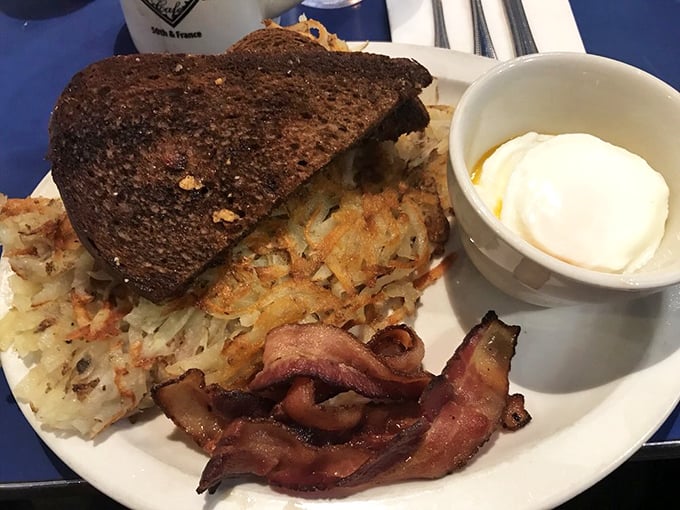 The holy trinity of breakfast: perfectly crisped hash browns, dark rye toast, and bacon that snaps like a Minnesota winter branch.