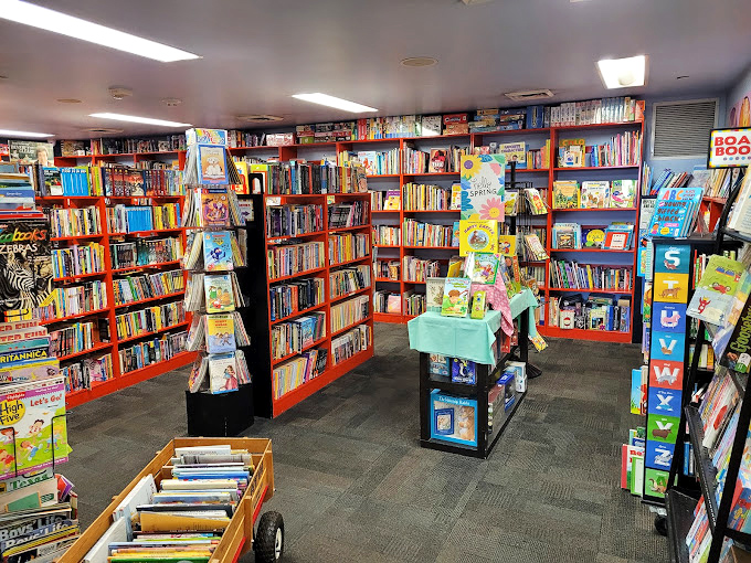 The children's section explodes with color and possibility. Those orange shelves aren't just holding books&mdash;they're launching pads for young imaginations.