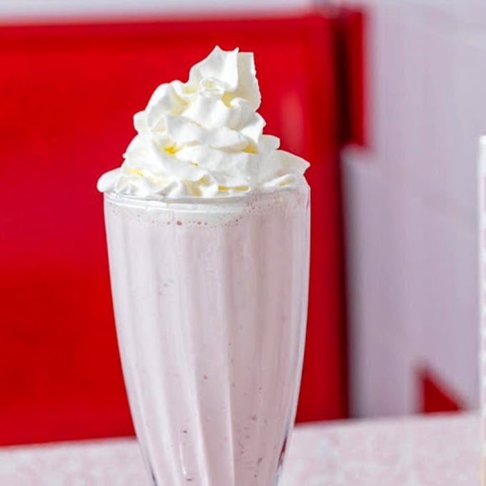 Vanilla milkshake mountain! This towering creation requires strategy: tackle the whipped cream summit first, then navigate the creamy valley below with equal parts straw and spoon.