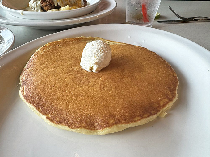This isn't just a pancake; it's a golden-brown canvas of possibility with a dollop of butter melting like morning sunshine.