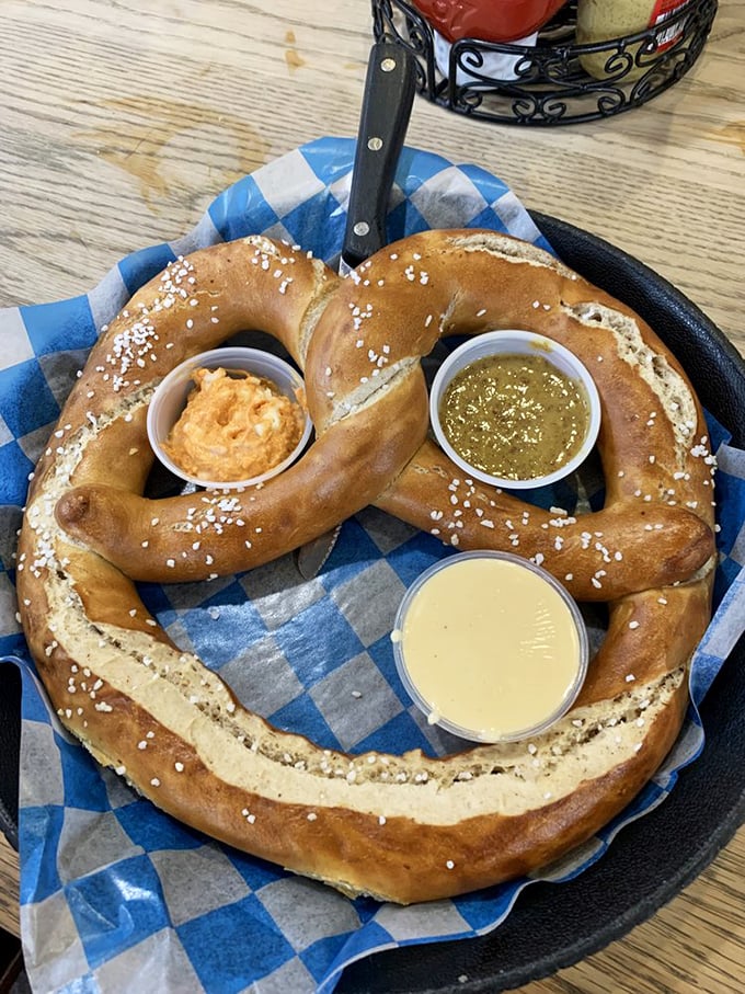 The pretzel arrives like a golden crown, its three dipping sauces standing ready like loyal courtiers to enhance your carb-laden bliss.