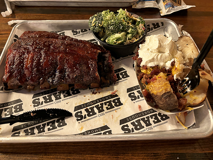 Behold the holy trinity of barbecue perfection: ribs with that mahogany bark, a loaded baked potato, and broccoli pretending it belongs at this meat party.