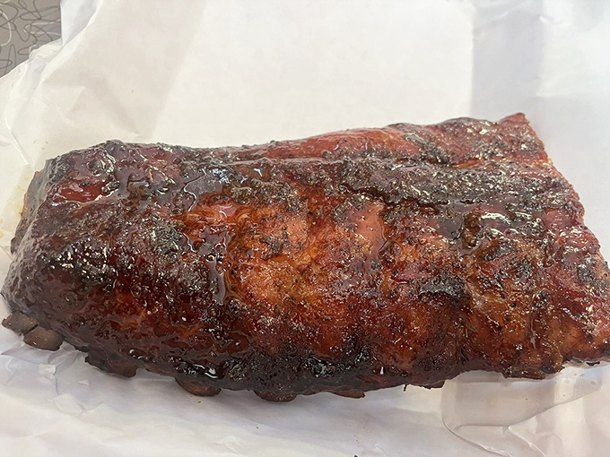 These ribs don't just fall off the bone - they practically leap into your mouth, their apricot-glazed crust glistening like edible stained glass.