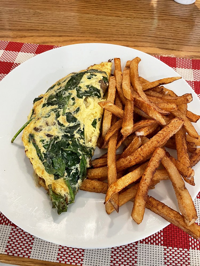 This isn't just any spinach omelet&mdash;it's a fluffy golden envelope delivering a special message from the breakfast gods. The fries are just the exclamation point.