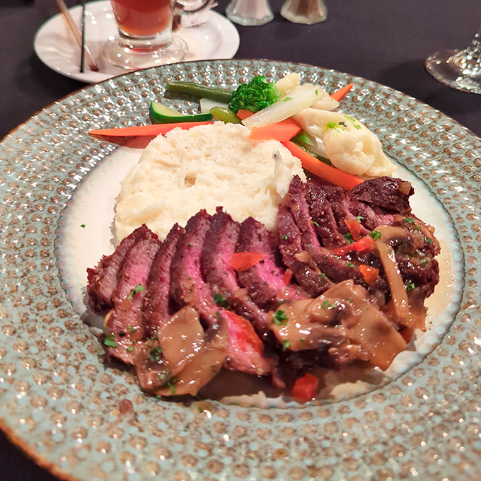 Behold the star of the show—perfectly cooked steak with mushroom sauce that would make vegetarians question their life choices.